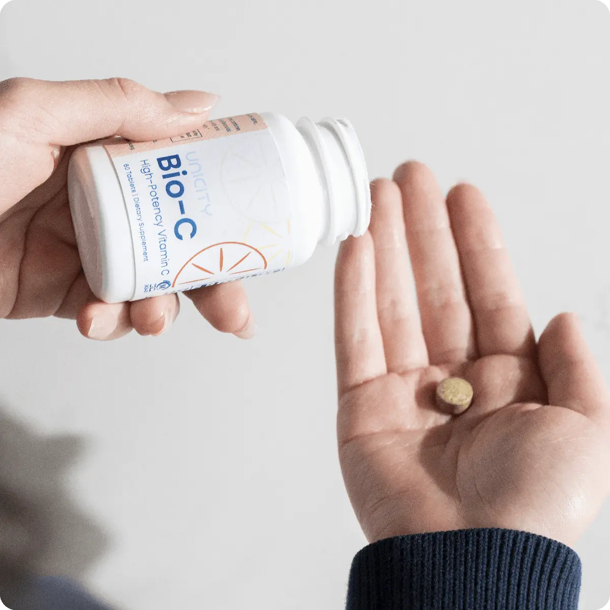 Persona con una pastilla de Bio-C en la mano