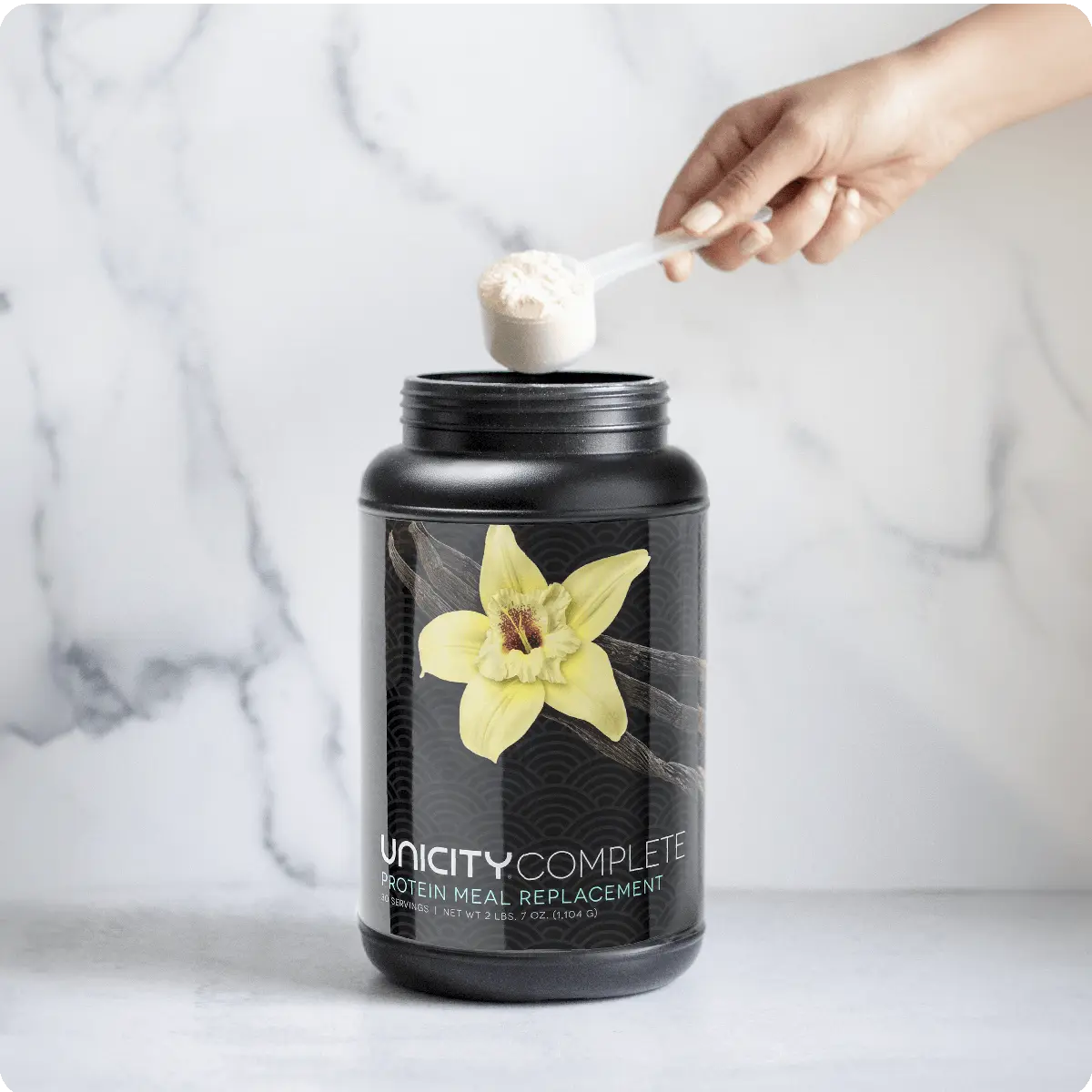 Mano con una cucharada de Complete de Unicity