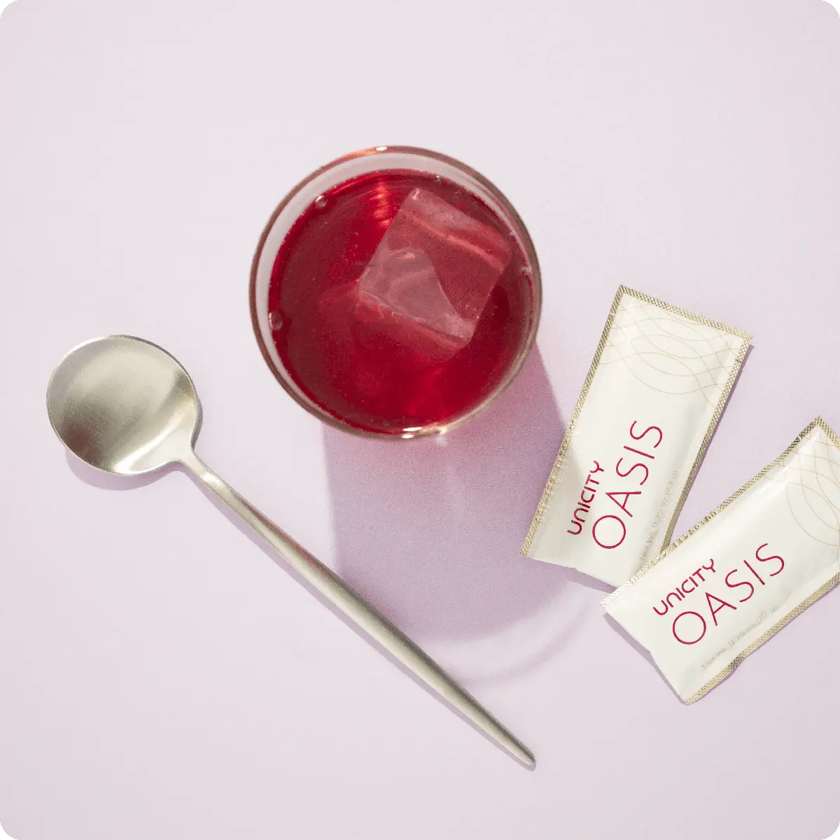 Vaso de Oasis de Unicity junto a los sobres