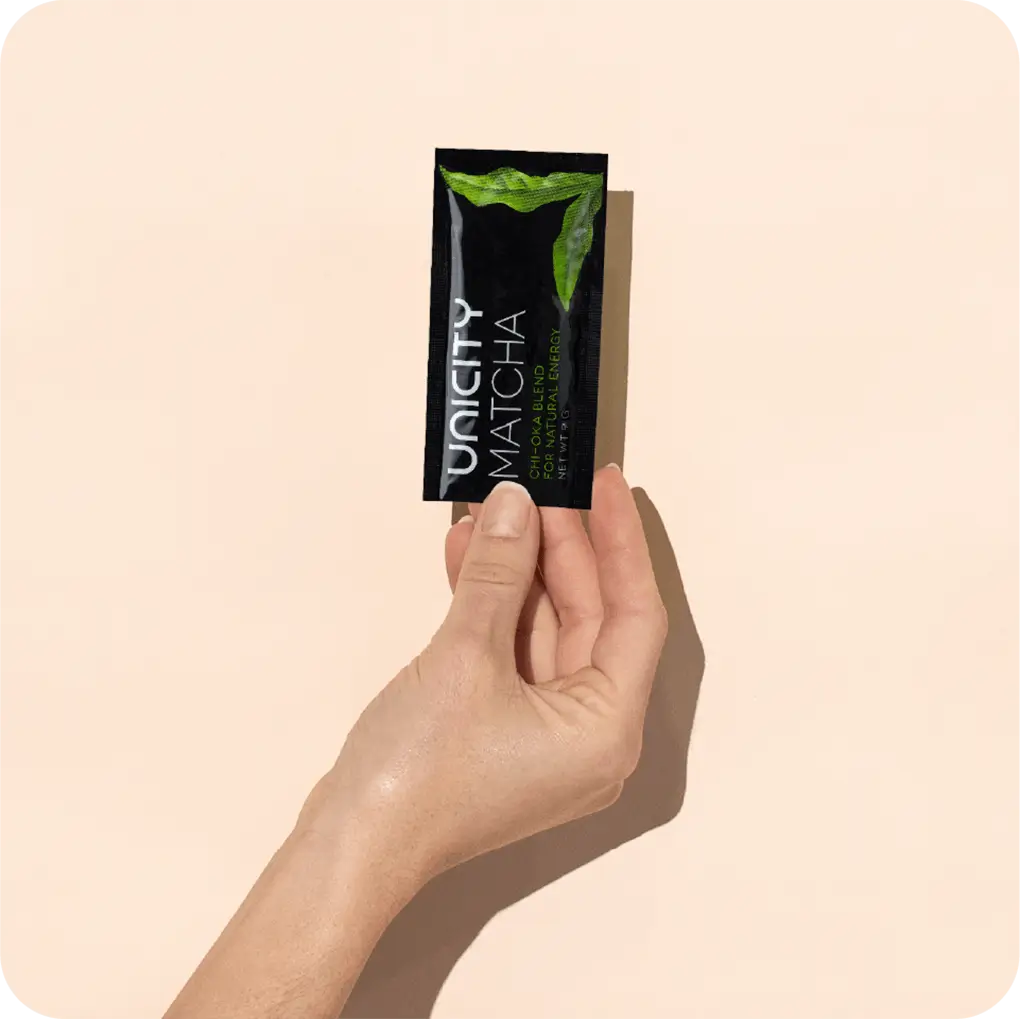 Hand holding Unicity's Matcha Energy packet