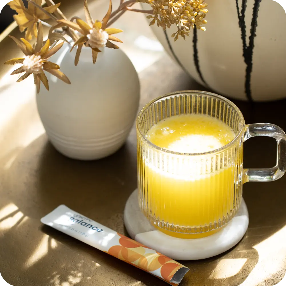 Glass of Unicity Balance next to stick pack